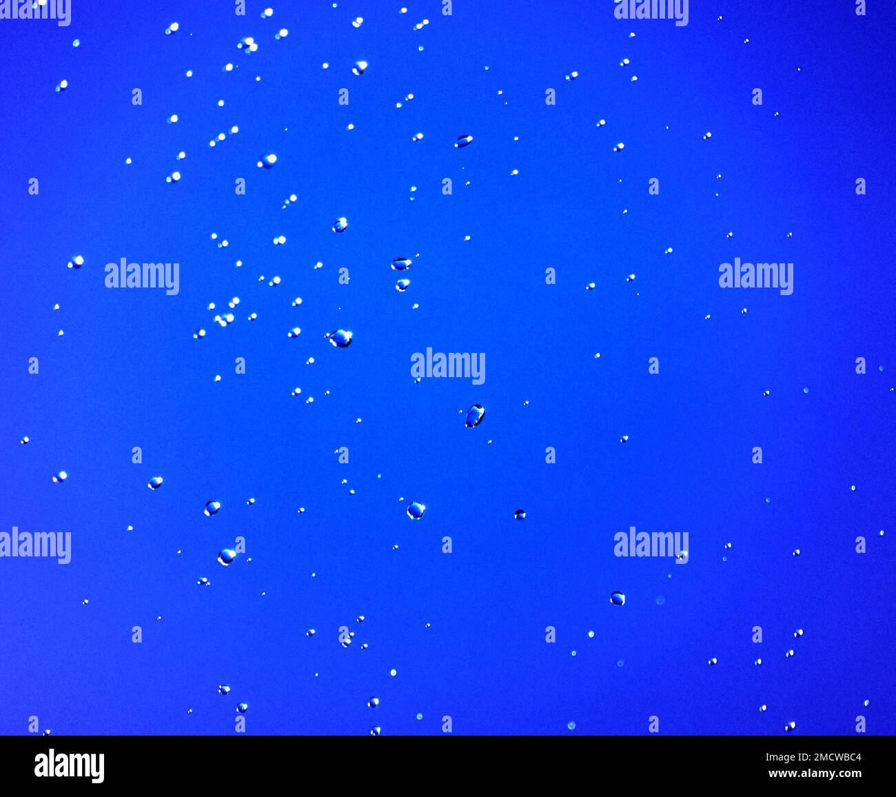 falling water drops on blue sky background Stock Photo - Alamy