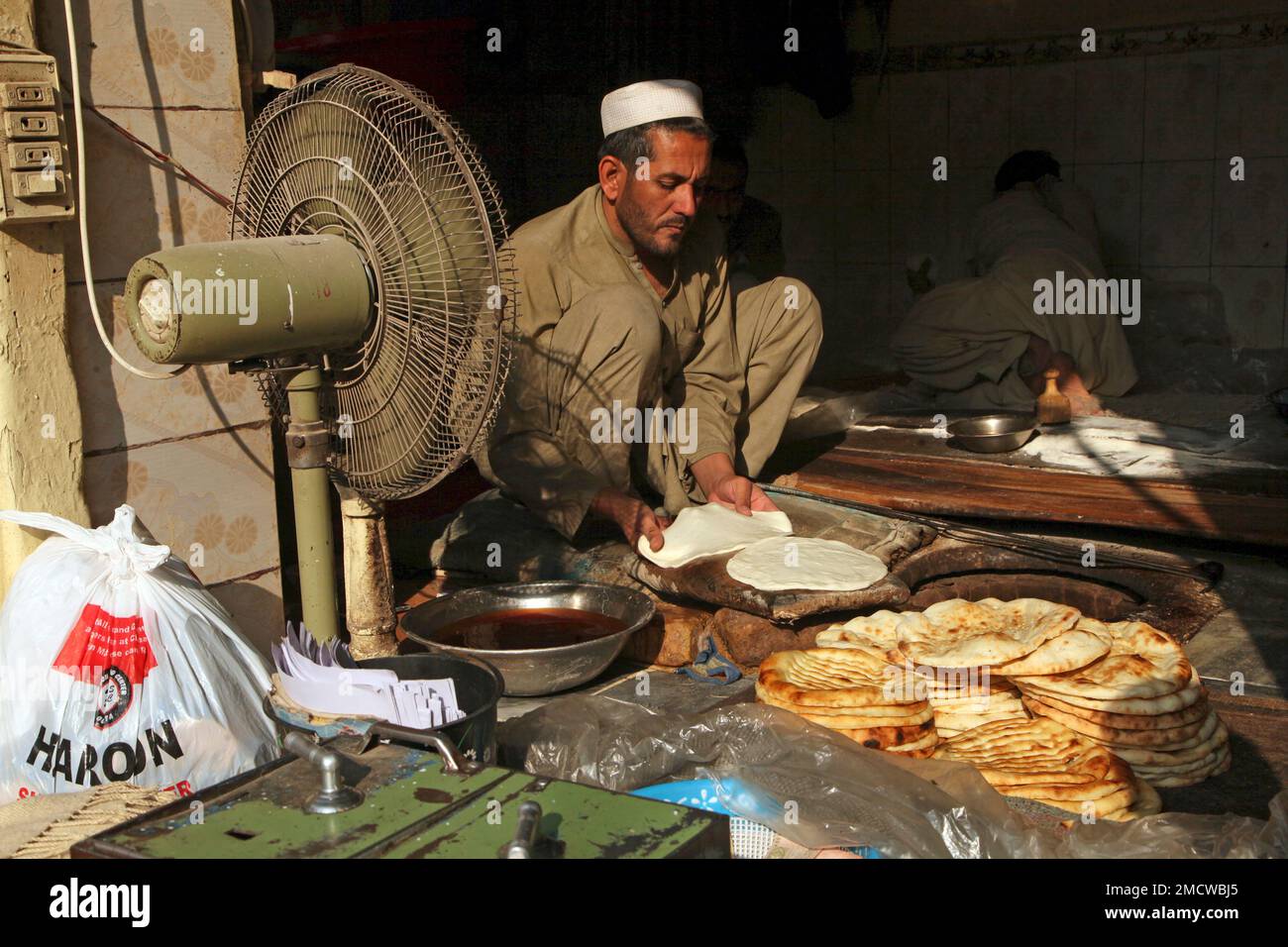 A man bakes local bread at a bakery in Peshawar, Pakistan, Friday, Nov ...