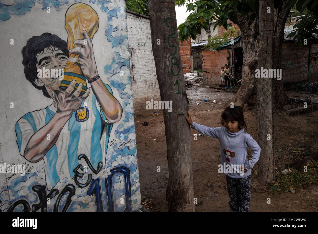 Mia, 6, stands next to a mural depicting the late soccer star Diego ...