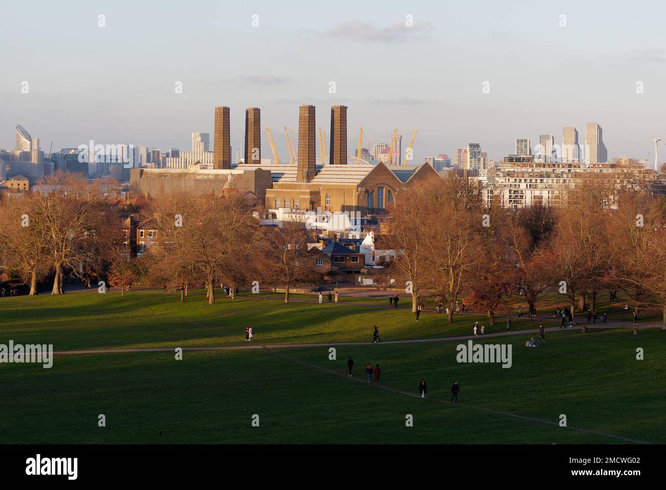 People walking on the pathways in Greenwhcih Park with a building with ...