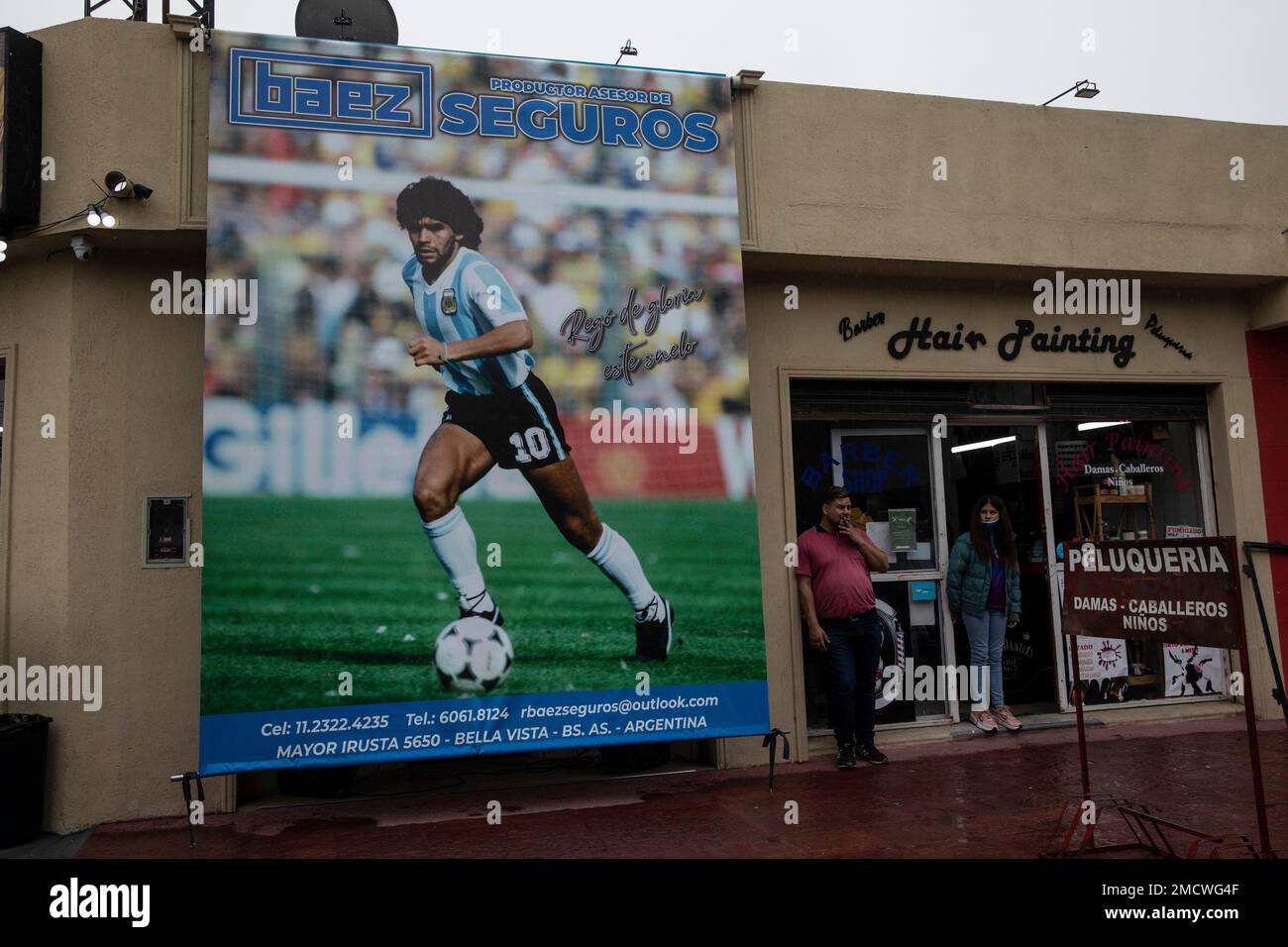 Workers stand next to a billboard featuring the late soccer star Diego ...
