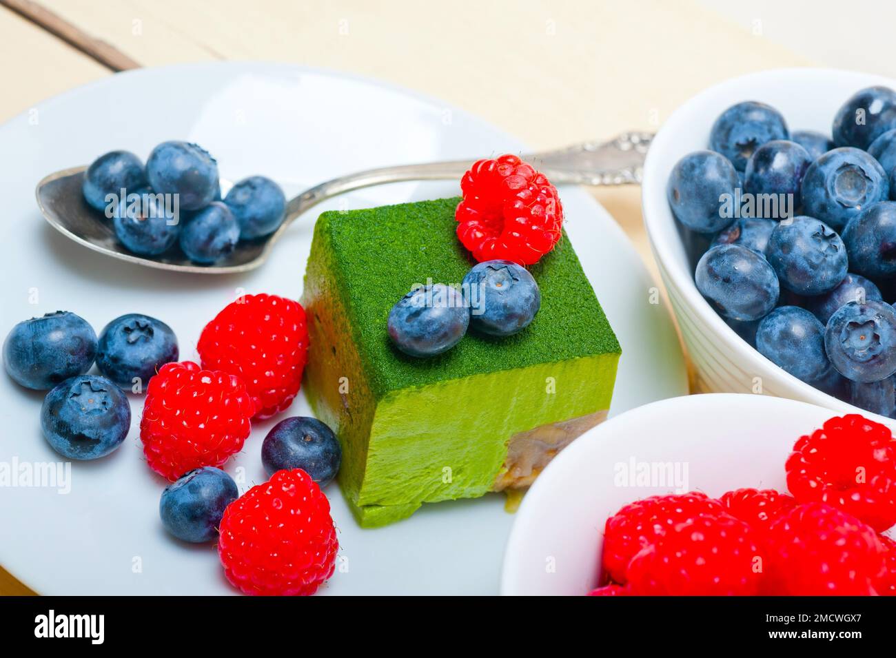 Green tea matcha mousse cake with raspberries and blueberries on top ...