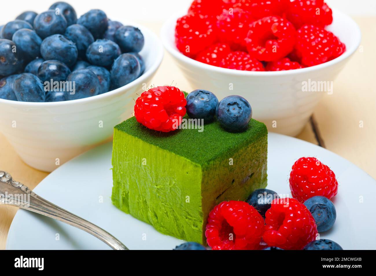 Green tea matcha mousse cake with raspberries and blueberries on top ...