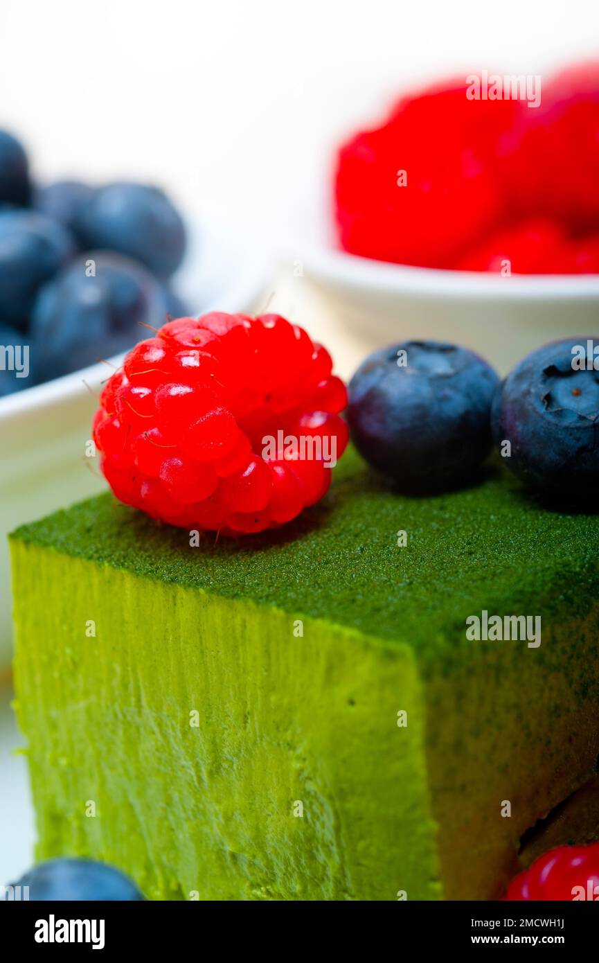 Green tea matcha mousse cake with raspberries and blueberries on top ...
