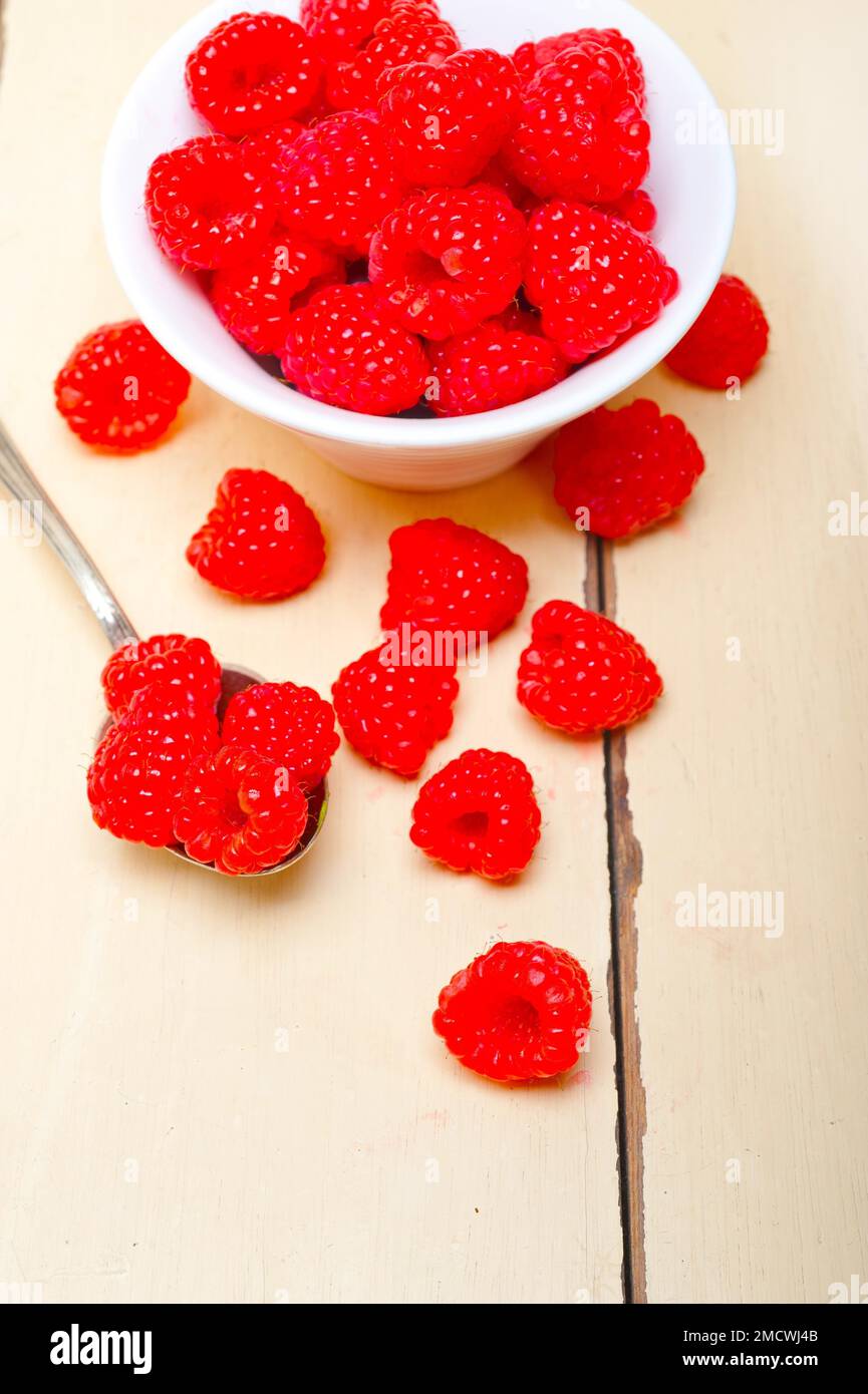 Bunch of fresh raspberry on a bowl and white wood rustic table Stock ...