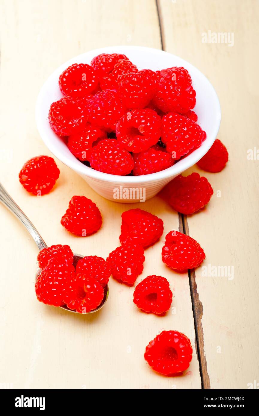 Bunch of fresh raspberry on a bowl and white wood rustic table Stock ...