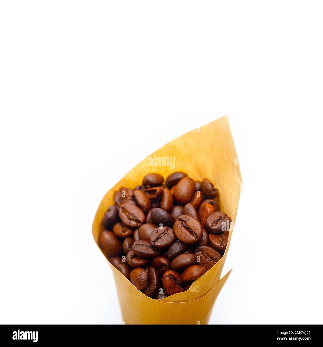 Espresso coffee beans on a paper cone cornucopia over white background ...