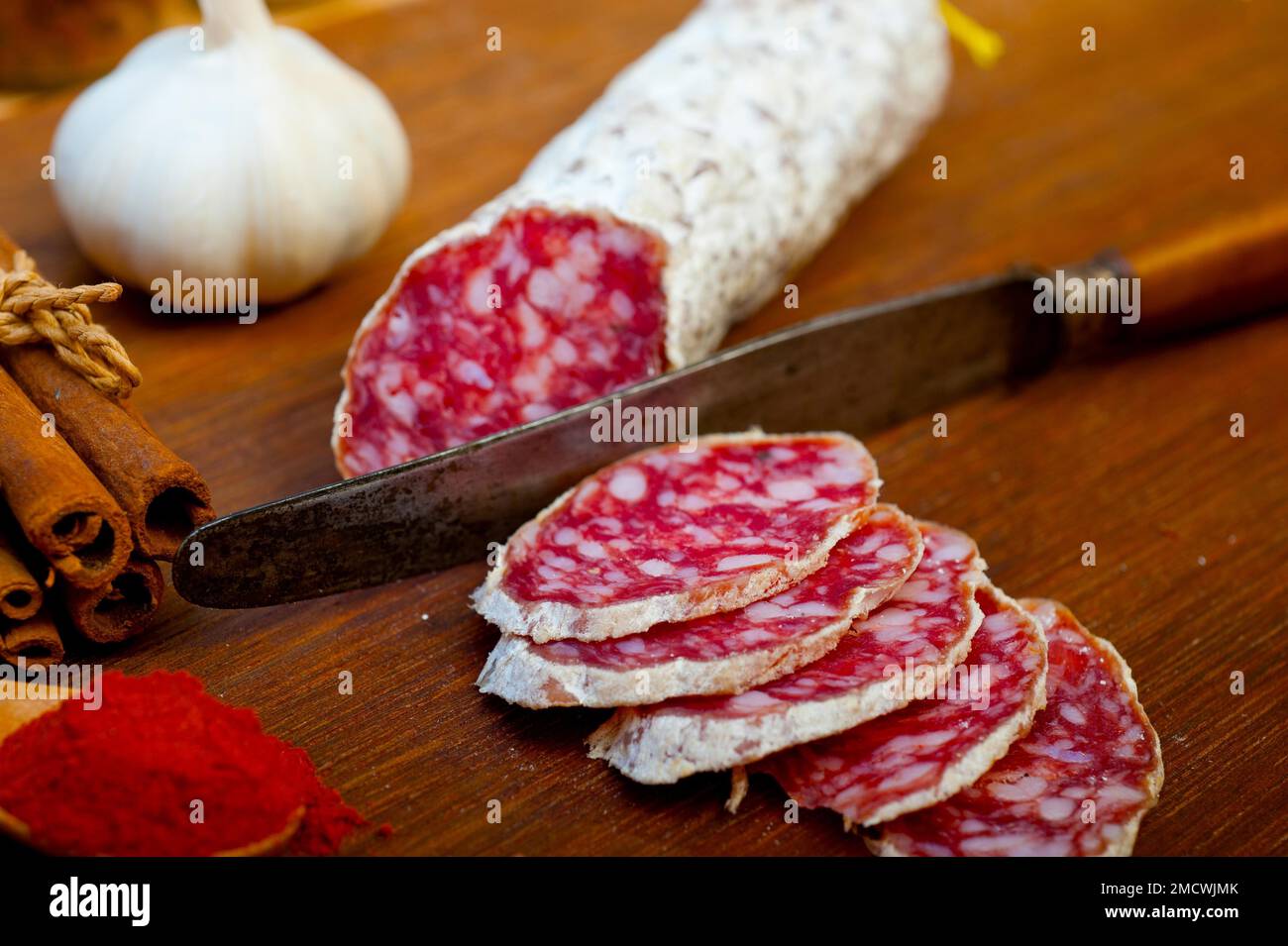 Traditional Italian salame cured sausage sliced on a wood board Stock ...