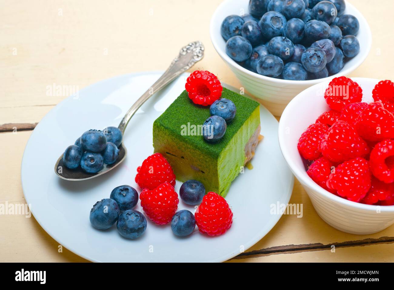 Green tea matcha mousse cake with raspberries and blueberries on top ...