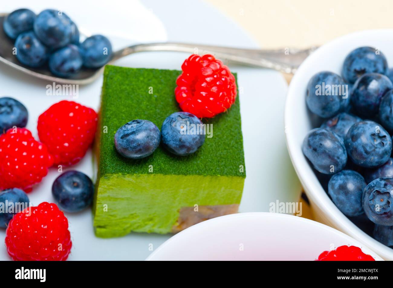 Green tea matcha mousse cake with raspberries and blueberries on top ...