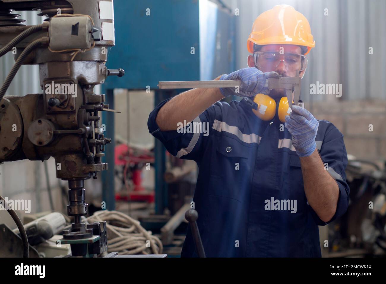 Young caucasian engineer man examining and measuring steel with ...