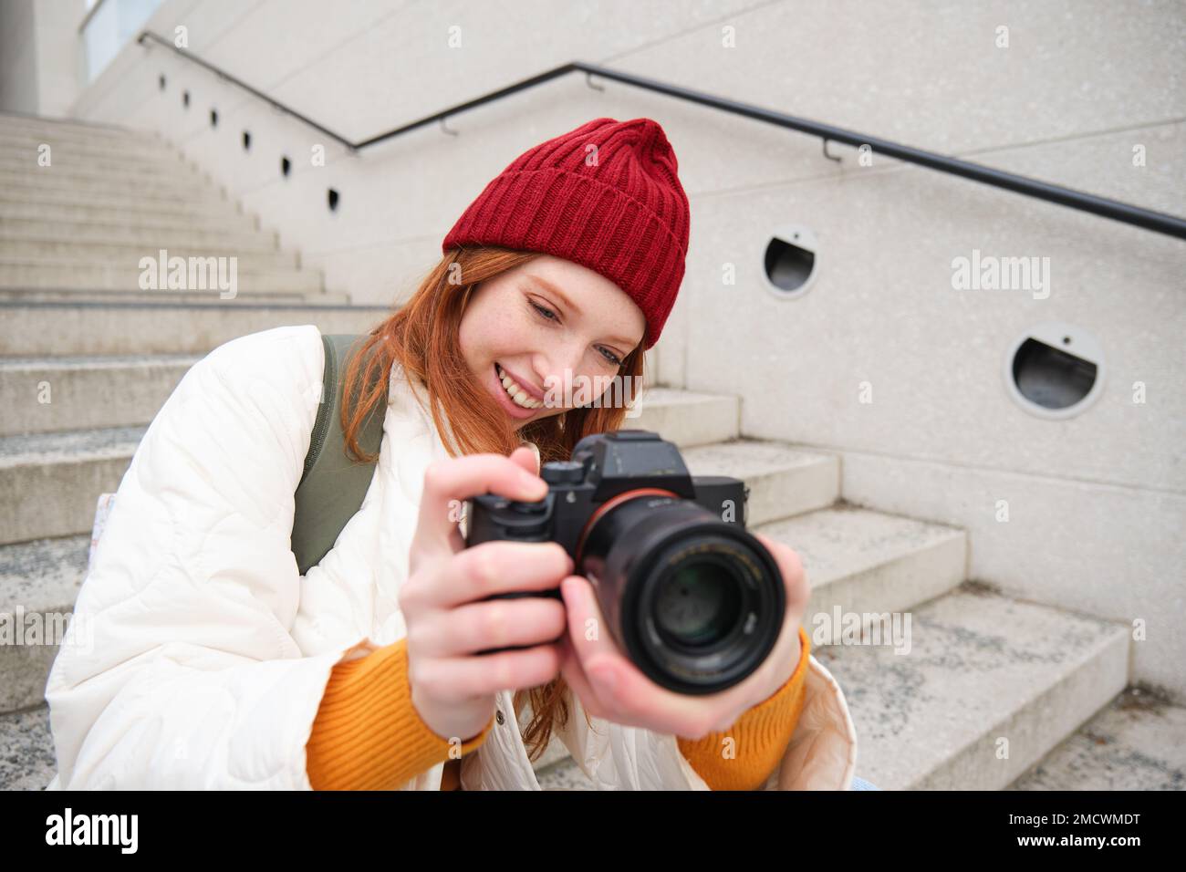 Portrait of female photographer walking around city with professional ...