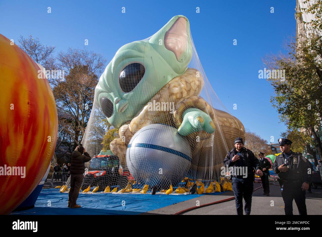 People walk by an inflated helium balloon of Grogu, also known as Baby ...