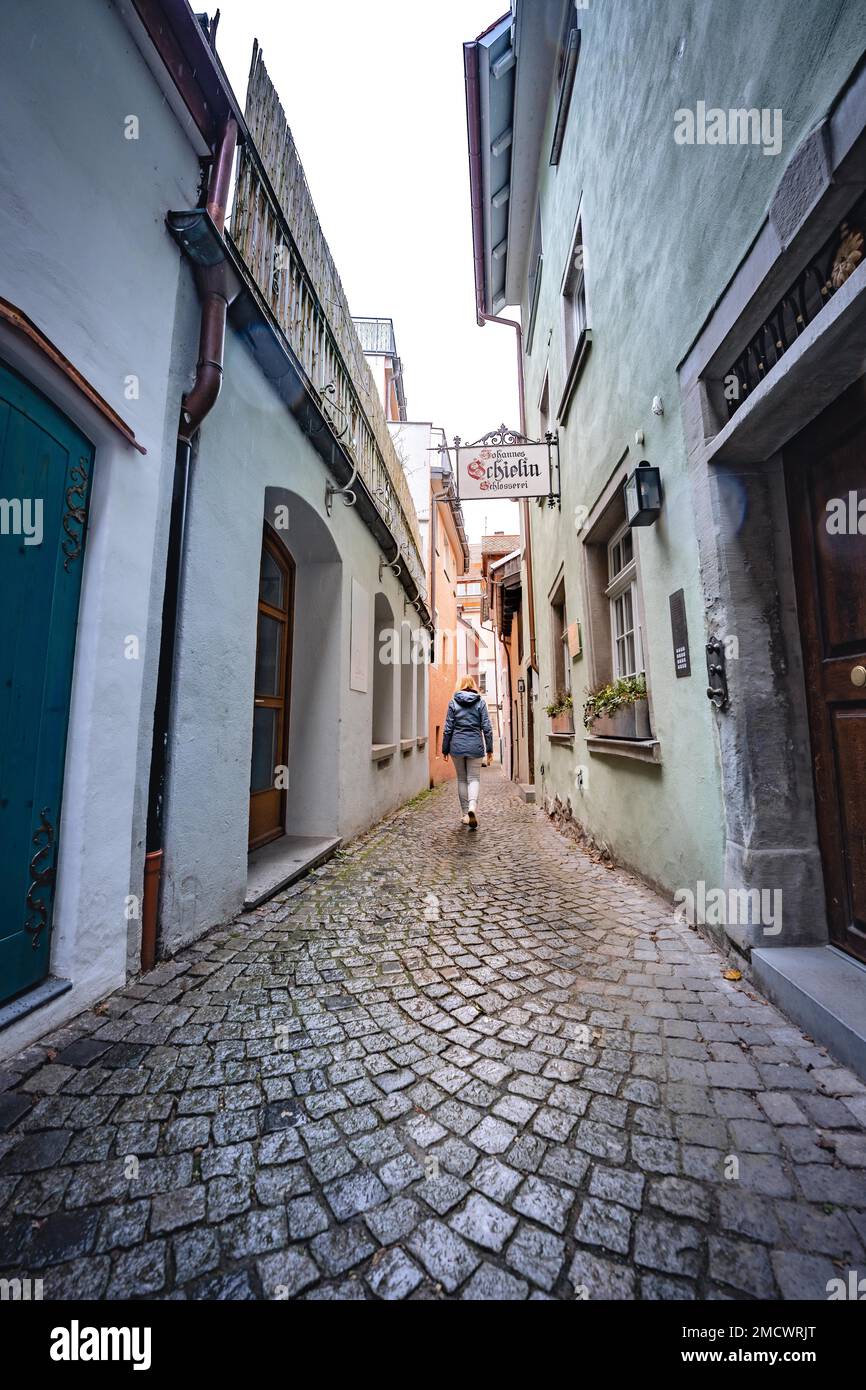 Narrow alleyway alley on a gloomy day with woman in the middle of the ...