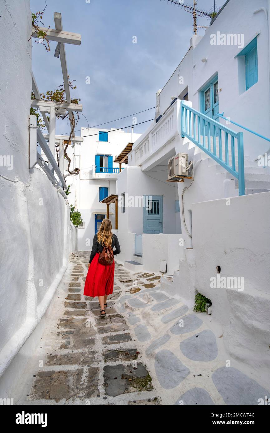 Young woman with red skirt in the alleys of the old town Chora ...