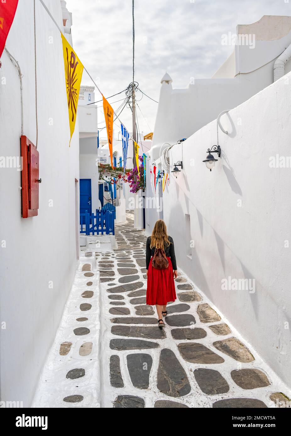 Young woman with red skirt in the alleys of the old town Chora ...