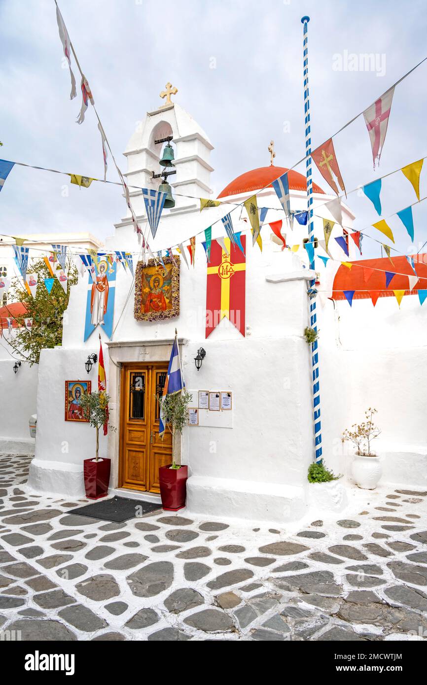 Cycladic Greek Orthodox Church decorated with flags, alleys of the old ...