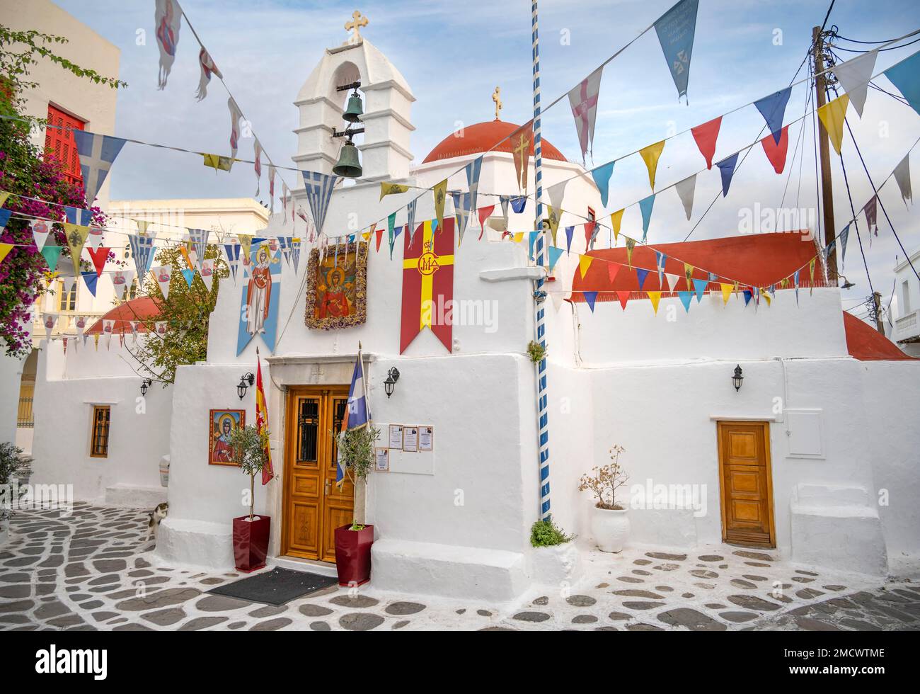 Cycladic Greek Orthodox Church decorated with flags, alleys of the old ...