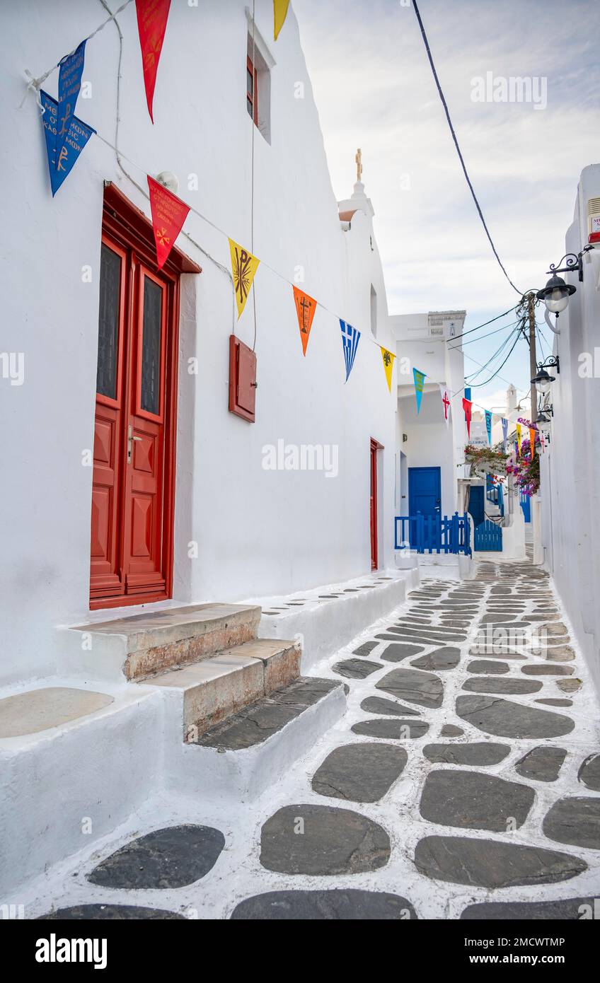 Cycladic Greek Orthodox Church decorated with flags, alleys of the old ...