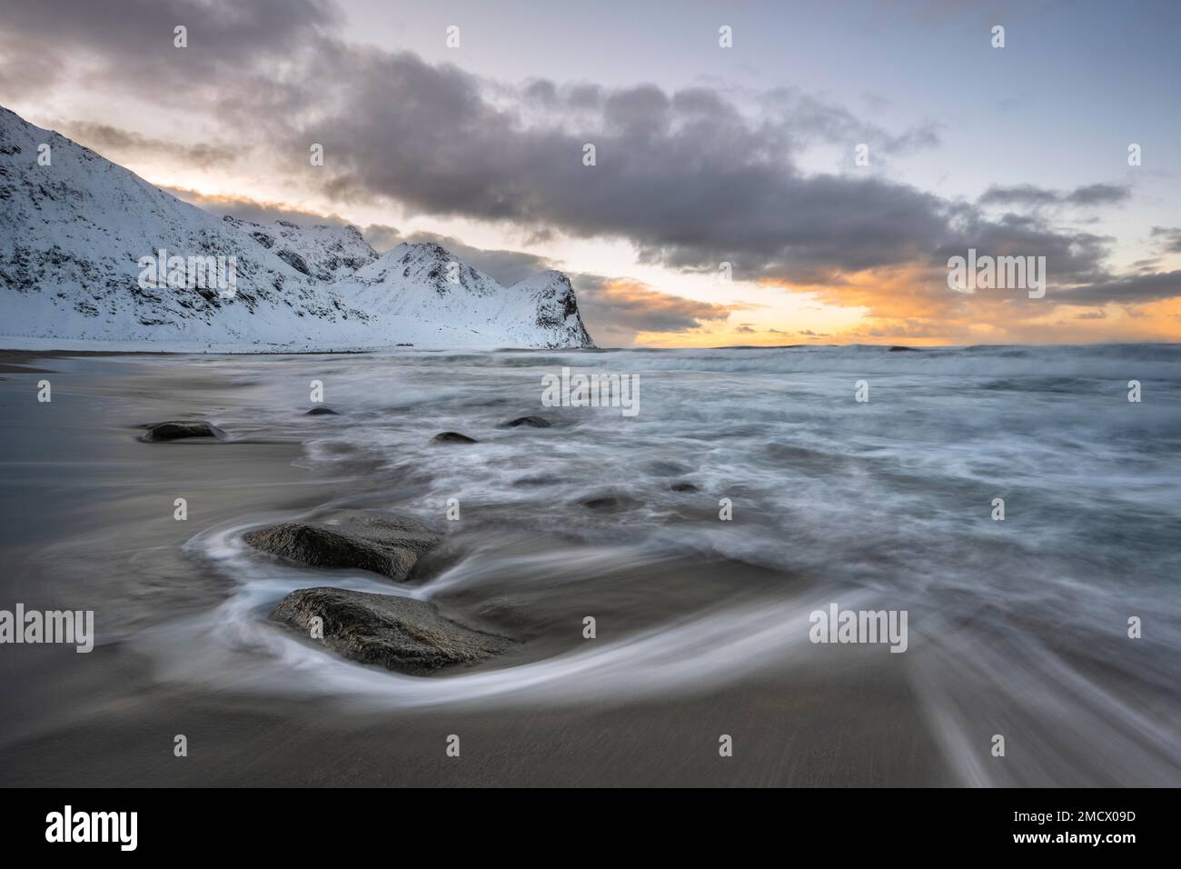 Beach with waves at sunset, Unstad Beach, Lofoten, Norway Stock Photo ...