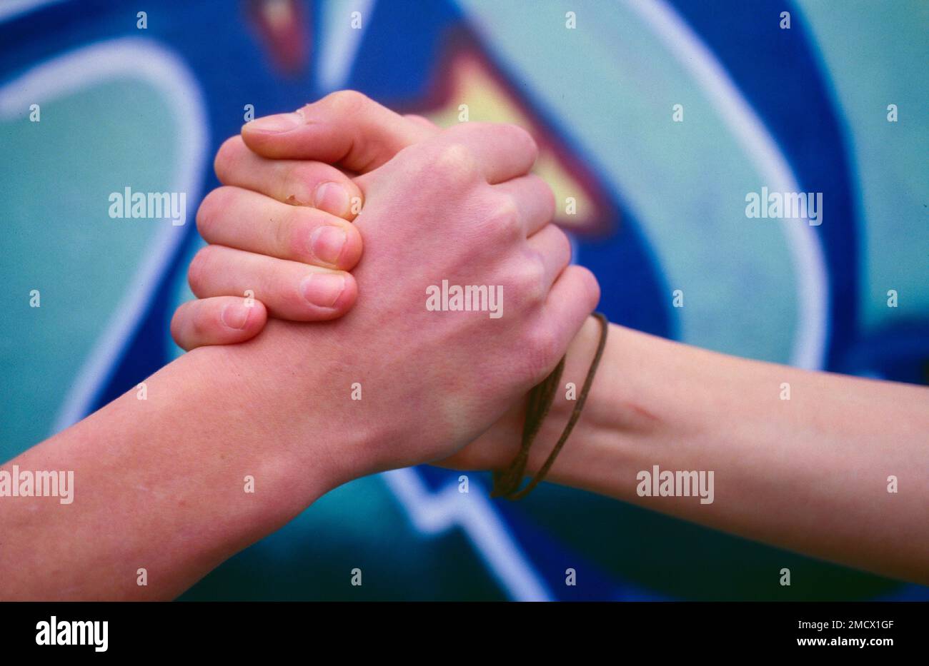 Young people shake hands in front of a graffiti wall, solidarity Stock ...