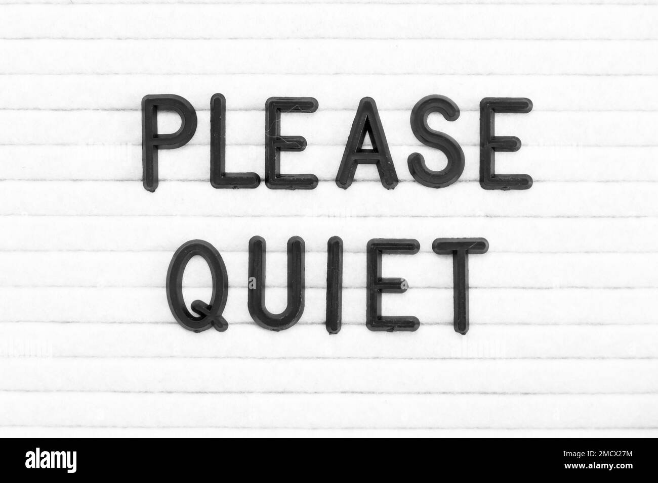 Black color letter in word please quiet on white felt board background ...