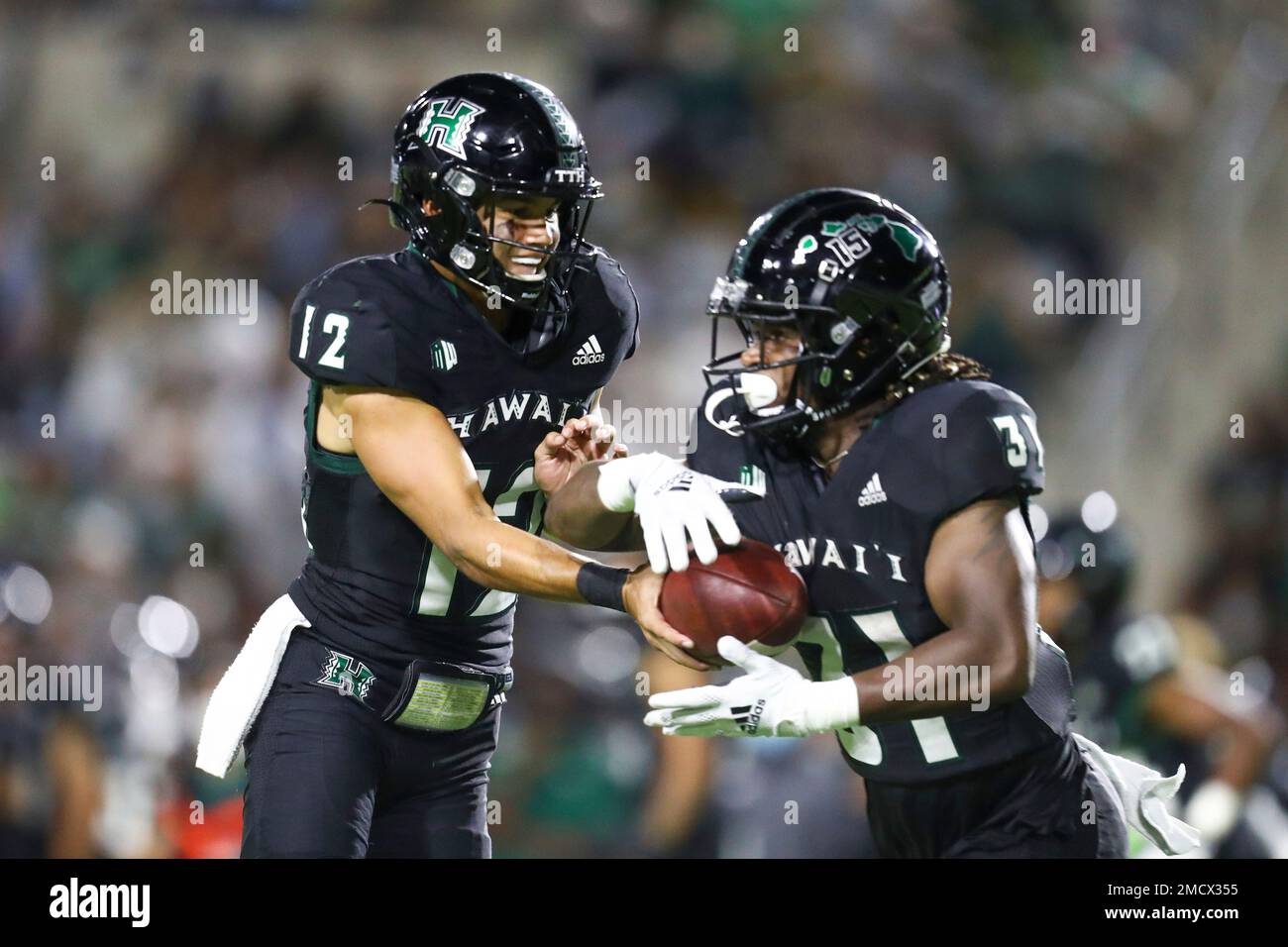 Hawaii quarterback Chevan Cordeiro (12) hands the ball off to running ...