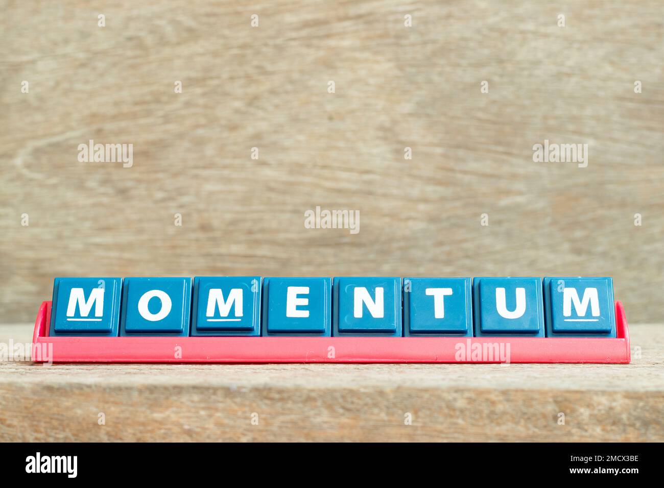 Tile alphabet letter with word momentum in red color rack on wood ...