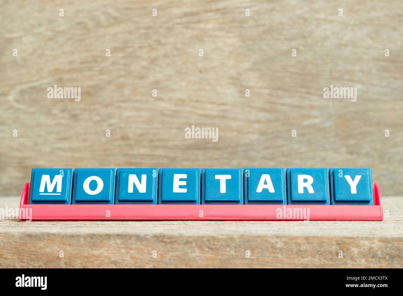 Tile alphabet letter with word monetary in red color rack on wood ...
