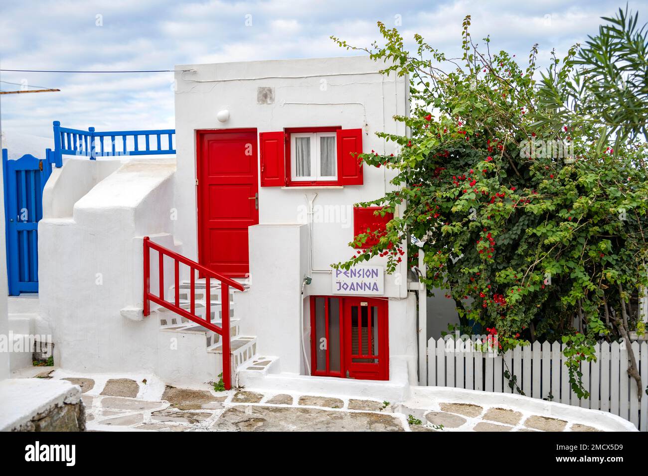 Cycladic white house with red shutters, alley of the old town Chora ...