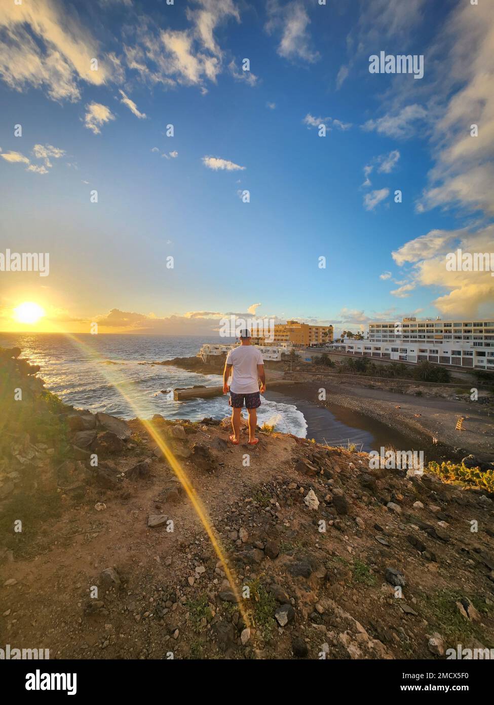A male standing on the beach looking at the beautiful sunset Stock ...