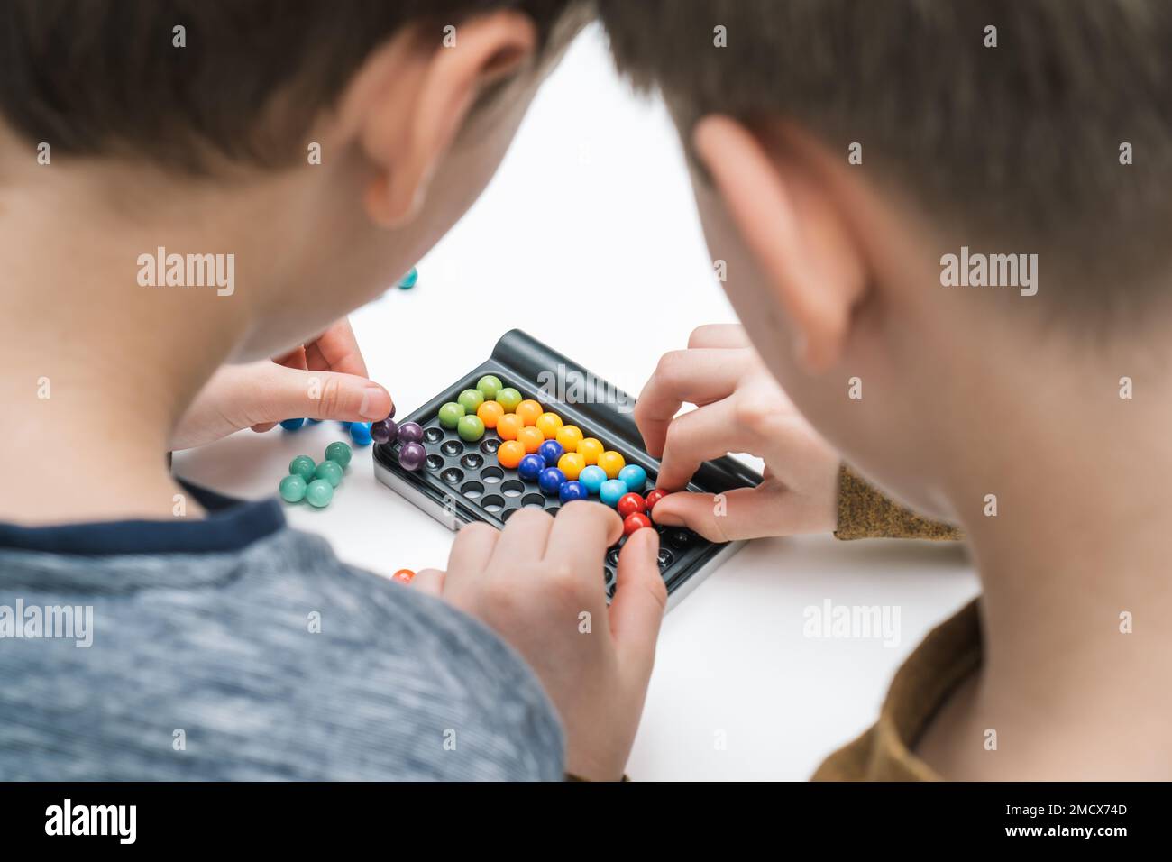 Top view of two boys friends playing colorful 3D puzzle classic pyramid ...