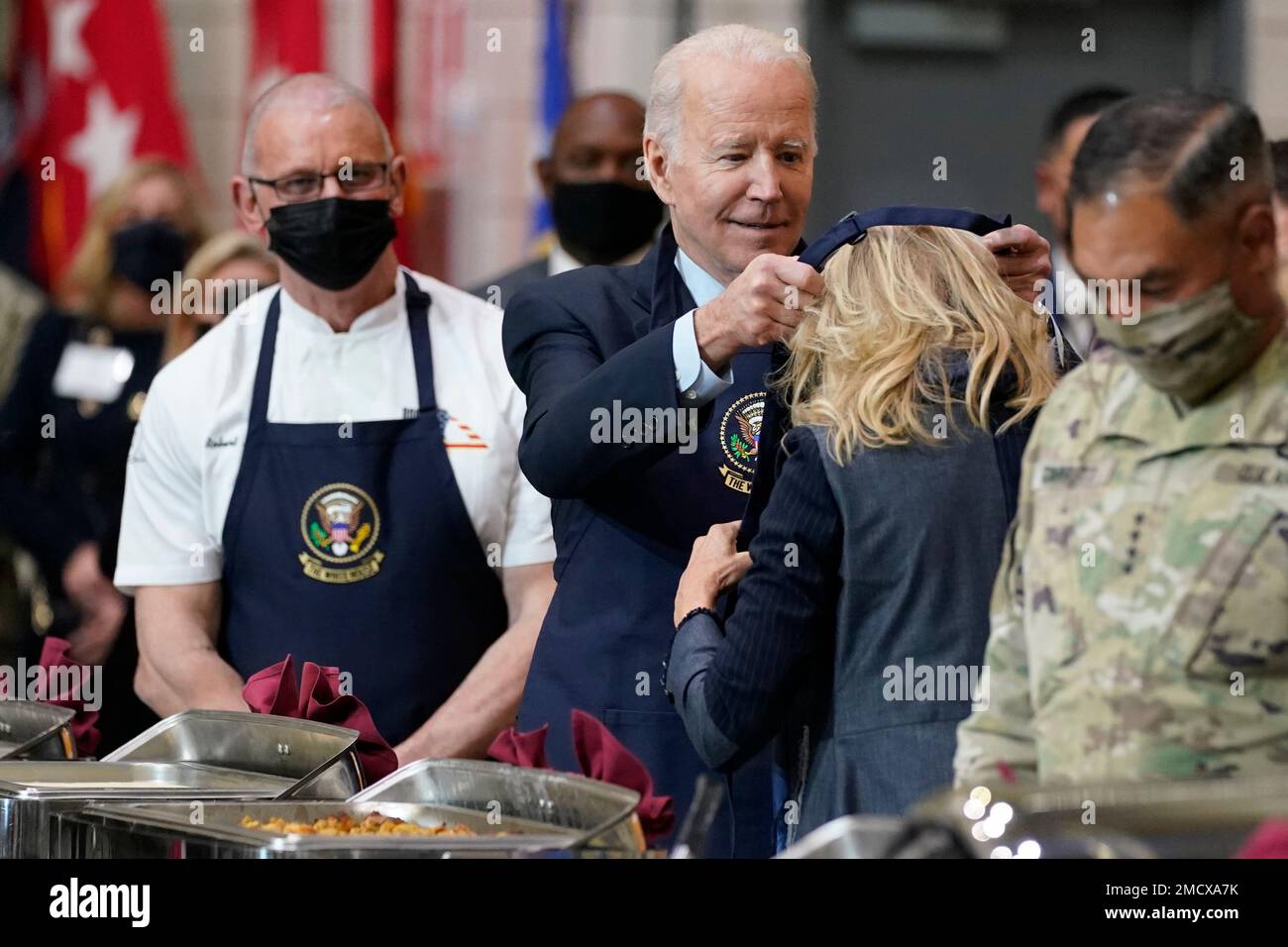 President Joe Biden puts an apron on first lady Jill Biden before they ...
