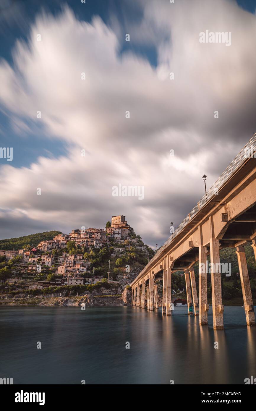 A vertical shot of a bridge above the lake leading to Castel di Tora in ...