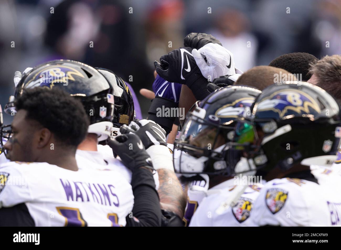 Baltimore Ravens players gather on the field before an NFL football ...