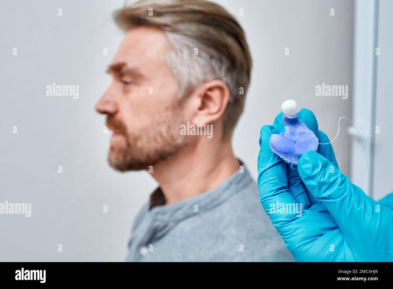 Audiologist holding molded individual earmolds for hearing aids of ...