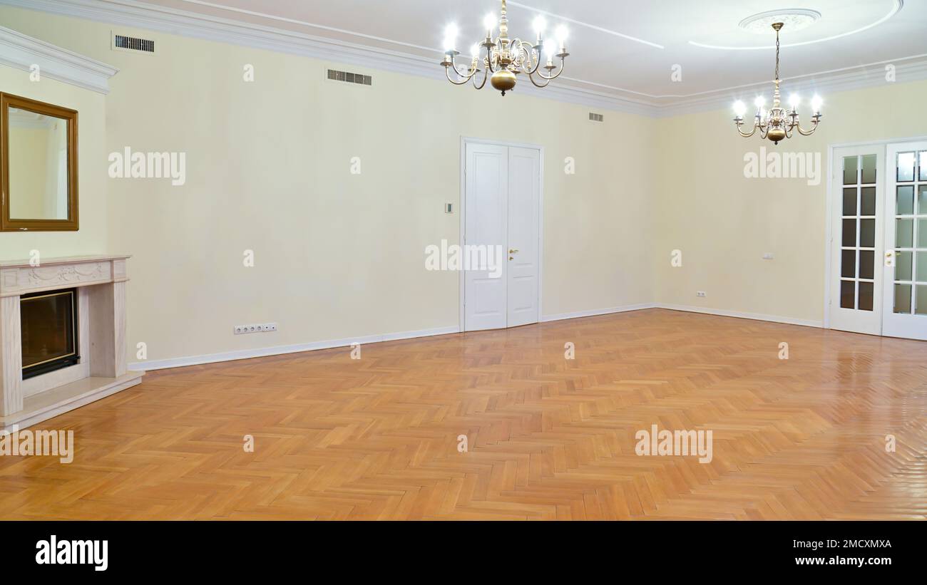 A huge empty room without furniture with laminate flooring and high ...