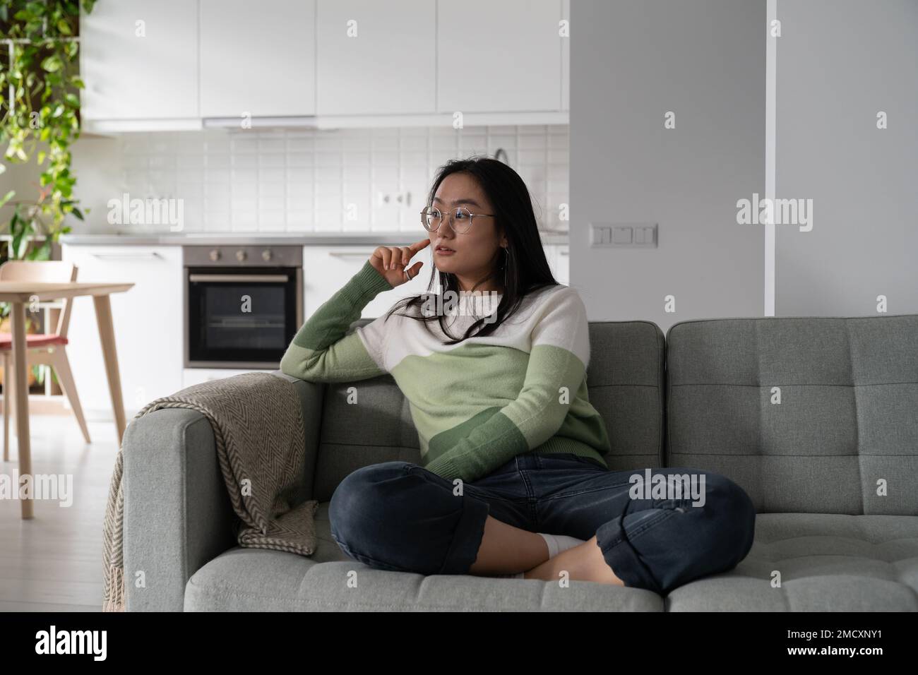 Concentrated pensive Asian girl student looks away thinking about ...