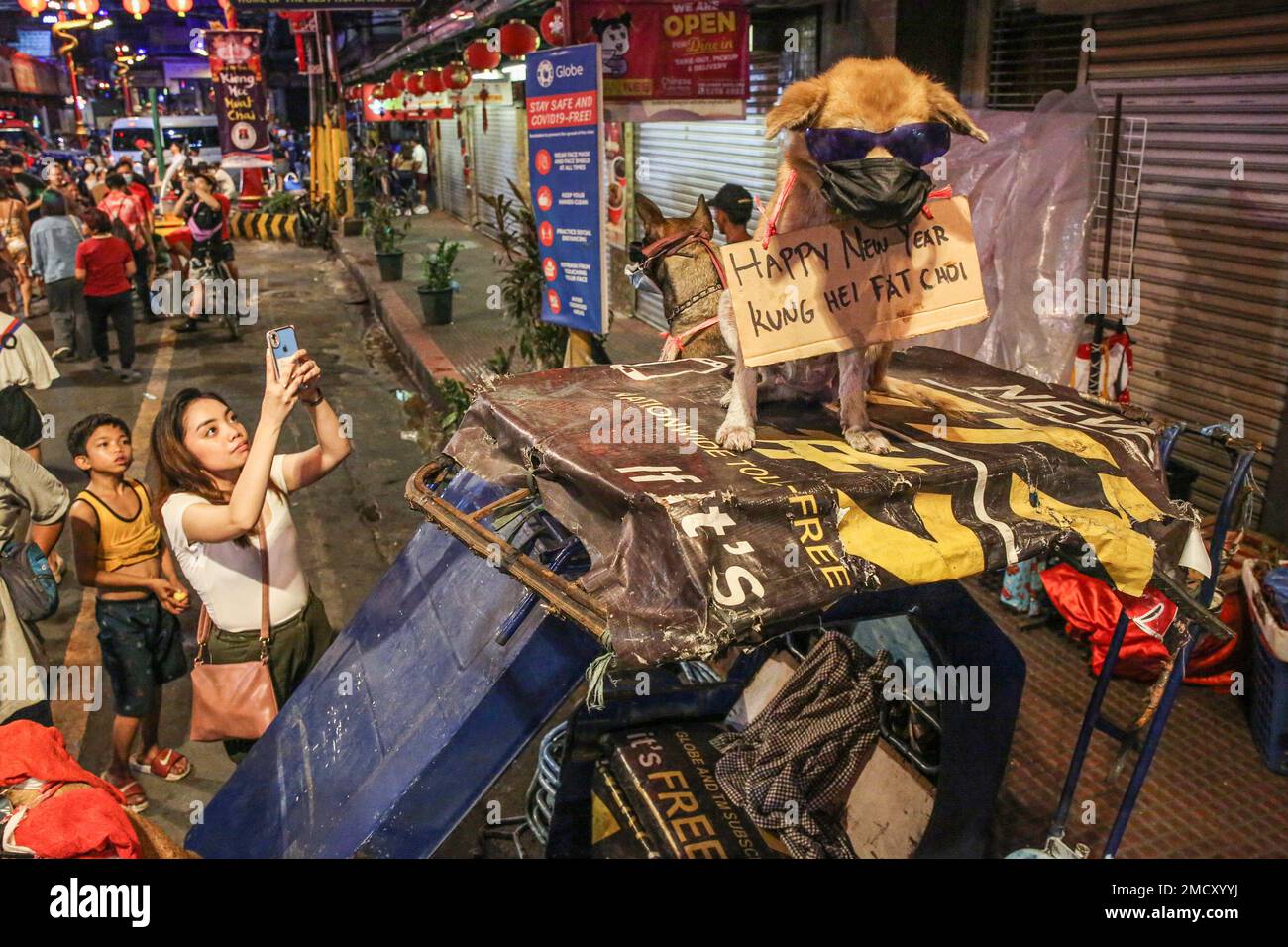 Manila, Philippines. 22nd Jan, 2023. A woman takes a photo of dogs ...