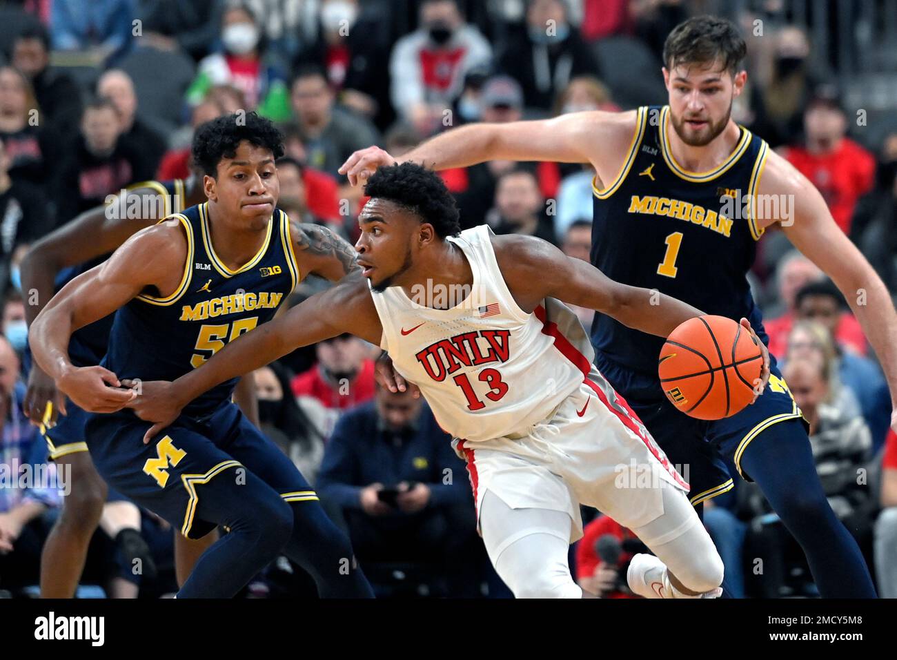UNLV guard Bryce Hamilton (13) is guarded by Michigan guard Eli Brooks ...