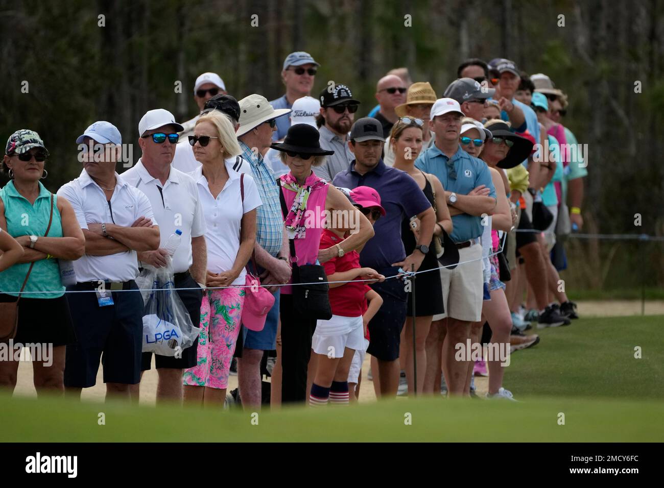 Spectators look on at the first hole green during the third round of ...
