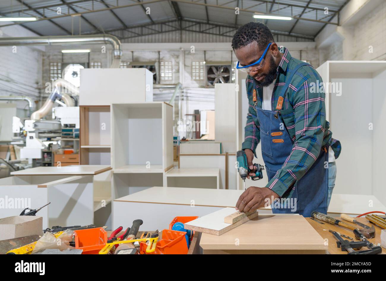 Short black hair man with moustache and beard use electric drill to ...