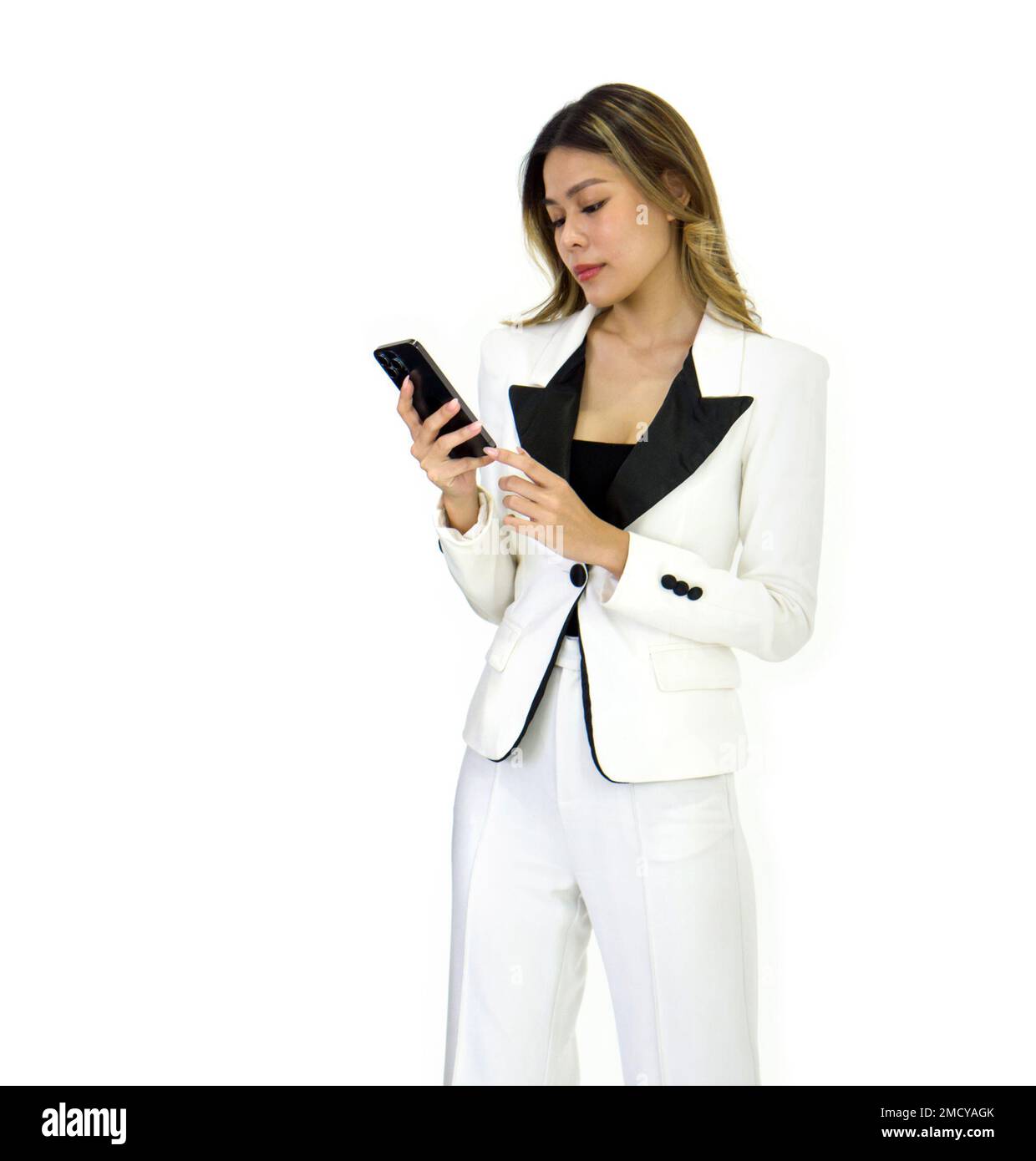 Young asian businesswoman in white suit reading text message on mobile ...