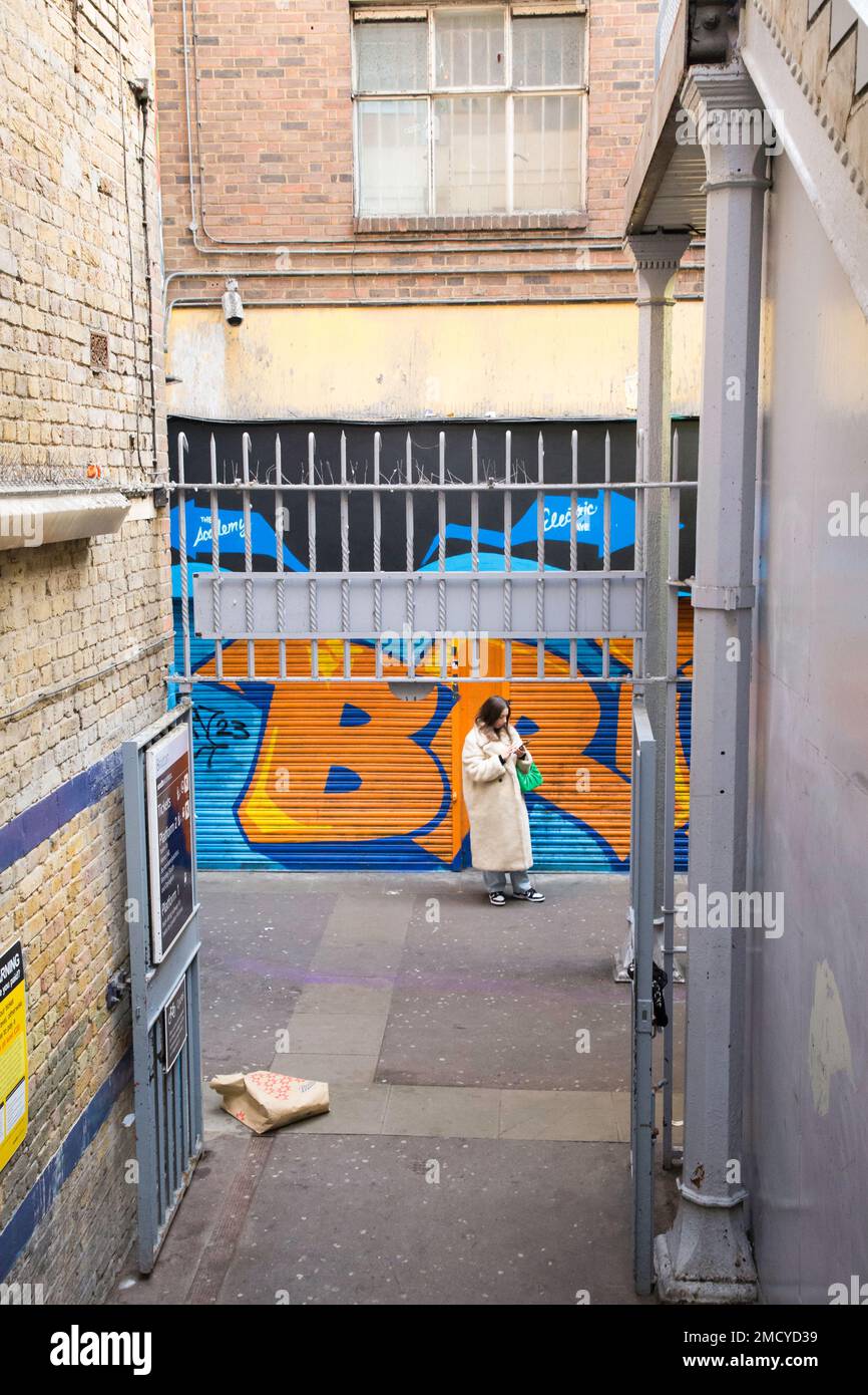 Lone Woman waiting in the urban graffiti of Brixton Station London ...