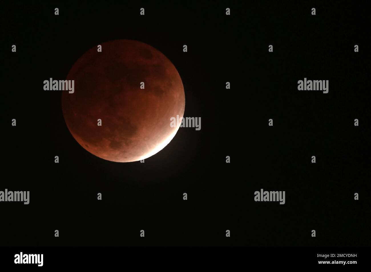 The earth's shadow covers the moon during a partial lunar eclipse ...