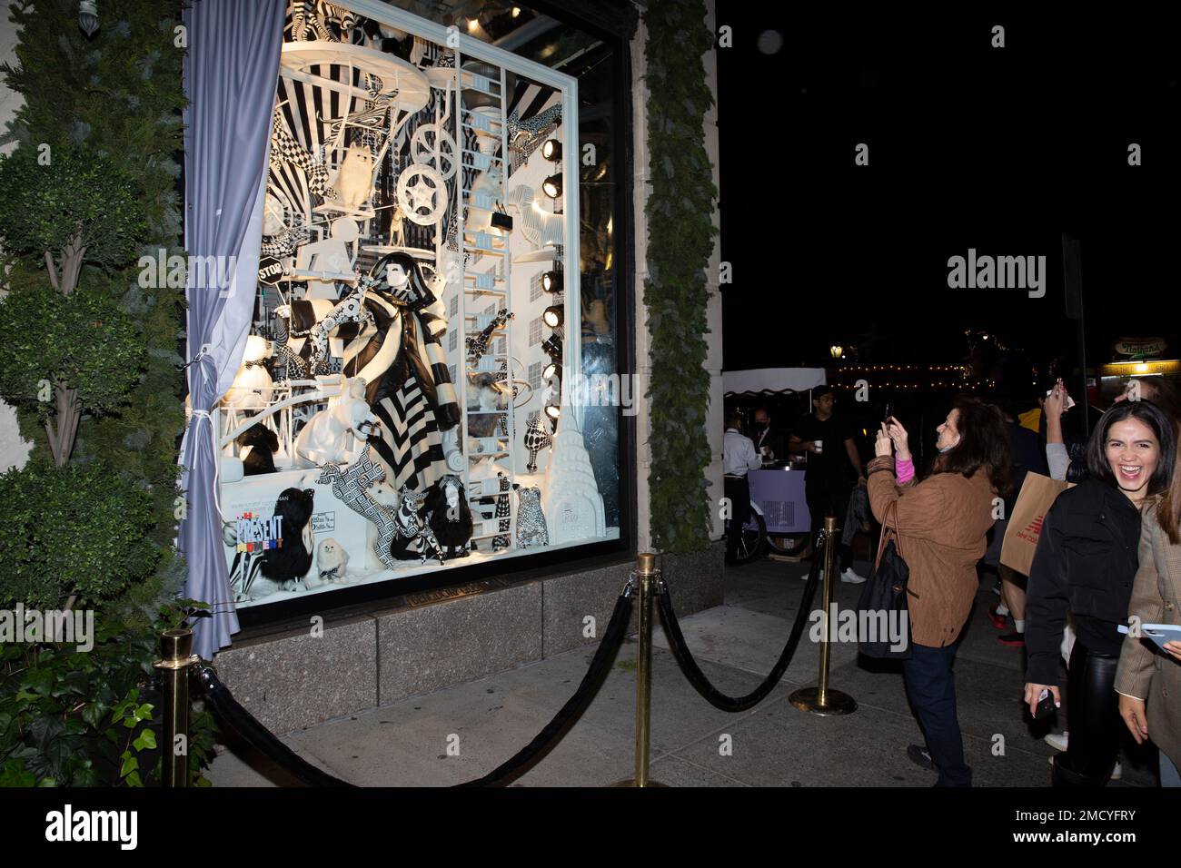 People look at and photograph the window displays after they were ...