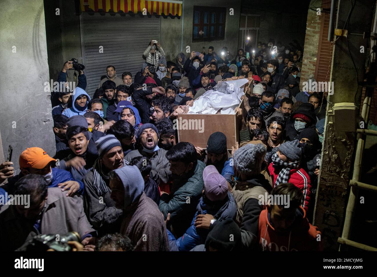 Relatives and neighbours shout slogans as they carry coffin containing ...