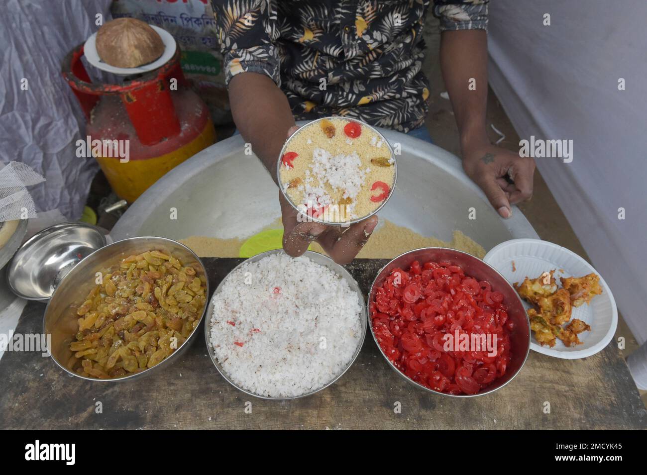 Dhaka. 22nd Jan, 2023. A vendor makes a type of Pitha at a stall during ...