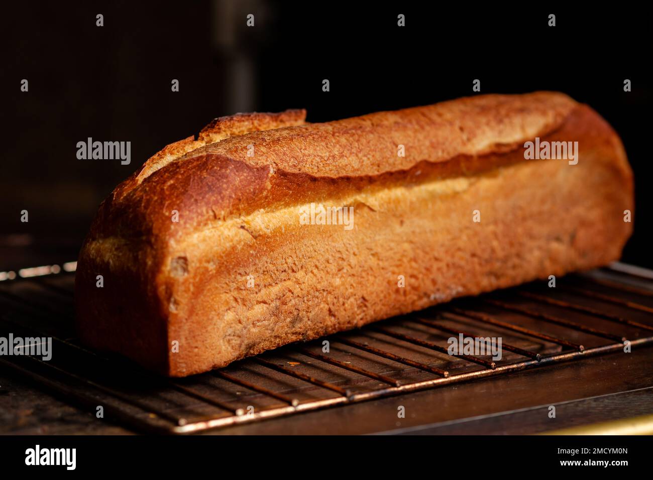 A loaf of French bread in an oblong shape on a dark background Stock ...