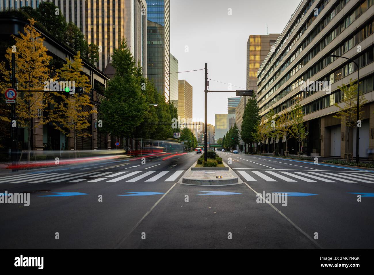 Traffic blurs through downtown intersection with early morning light ...